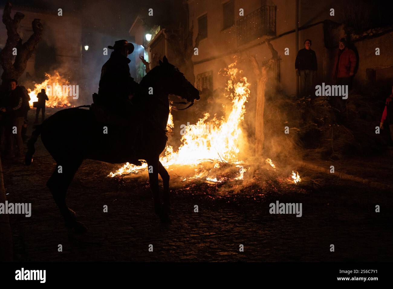 A horse jumps over a bonfire during the celebration of the Luminarias ...