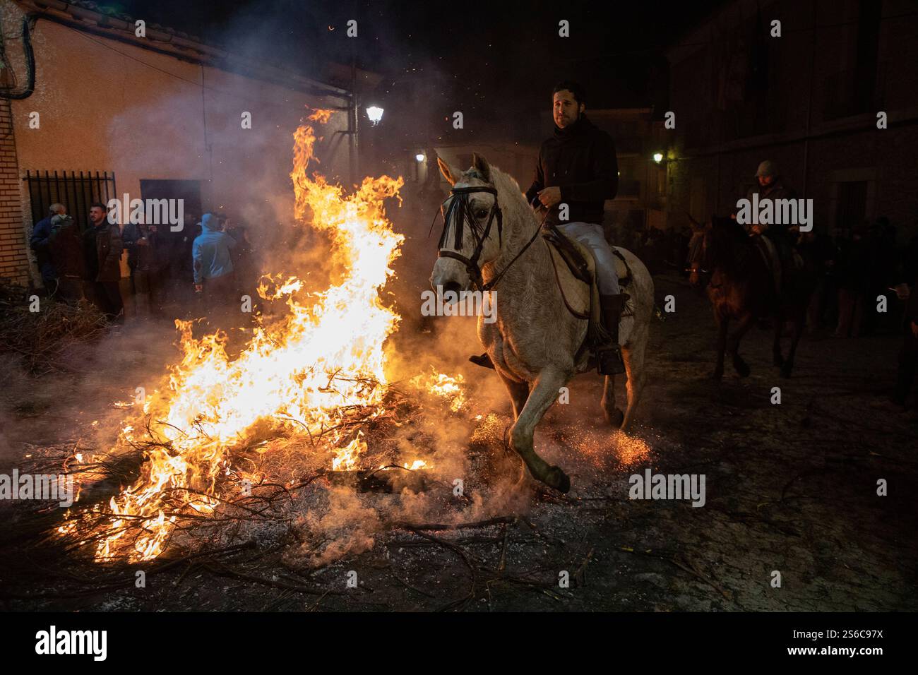 Two horses jump over a bonfire during the celebration of the Luminarias ...