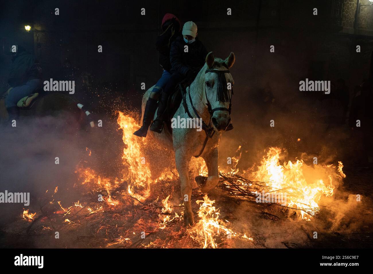 A horse jumps over a bonfire during the celebration of the Luminarias ...