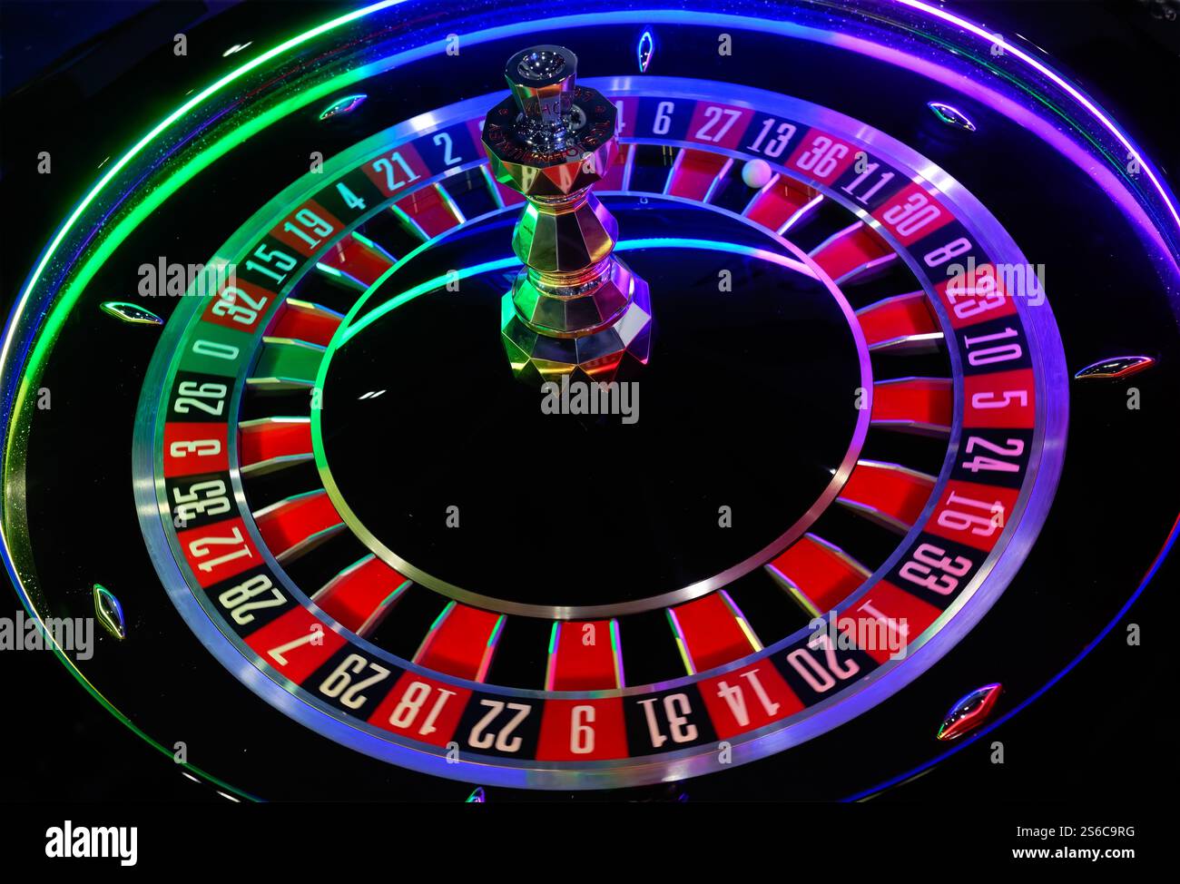 Glass spindle on a colourfully lit roulette wheel Stock Photo - Alamy