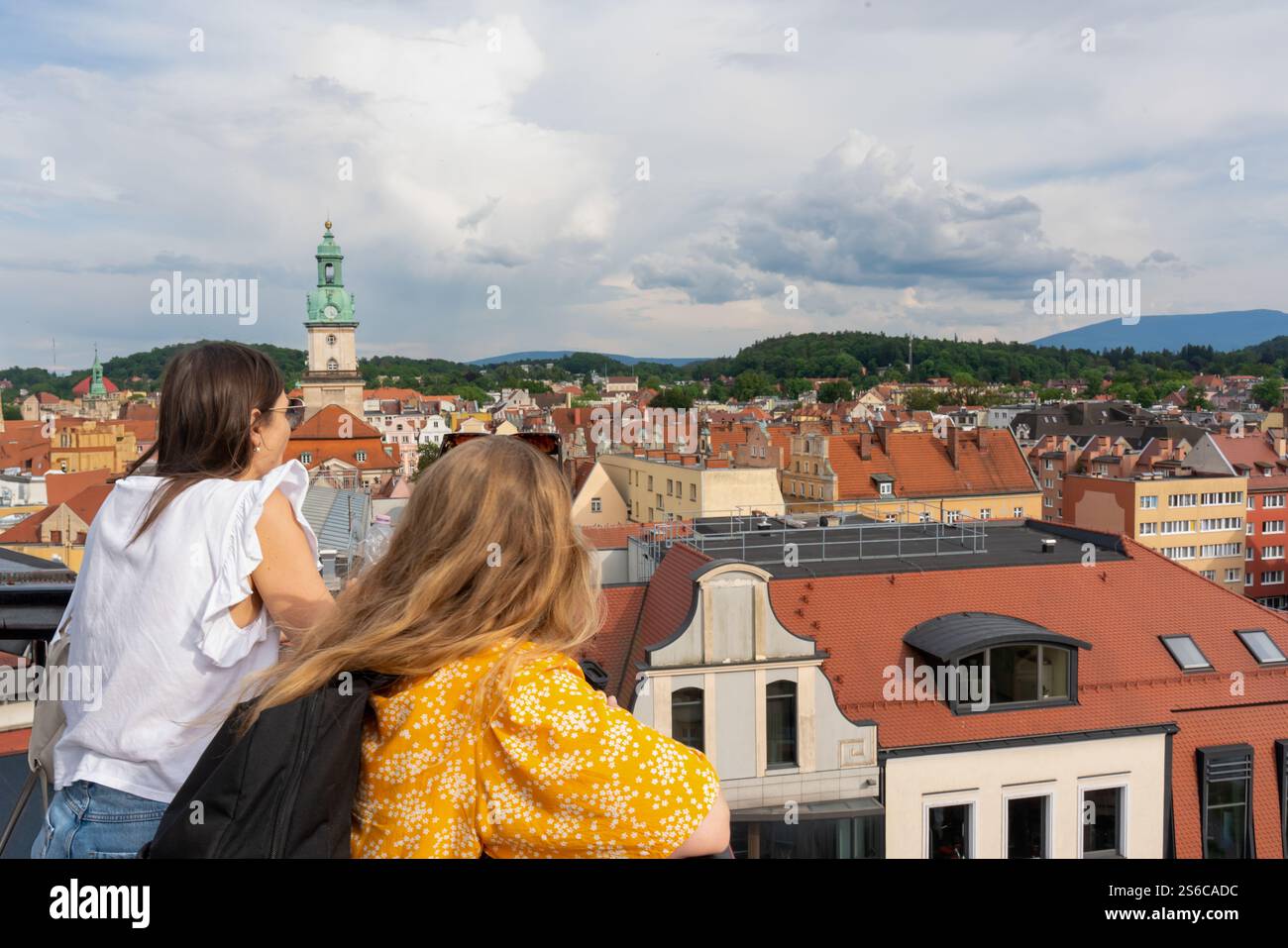 Two women enjoying panoramic view of charming European city with red ...