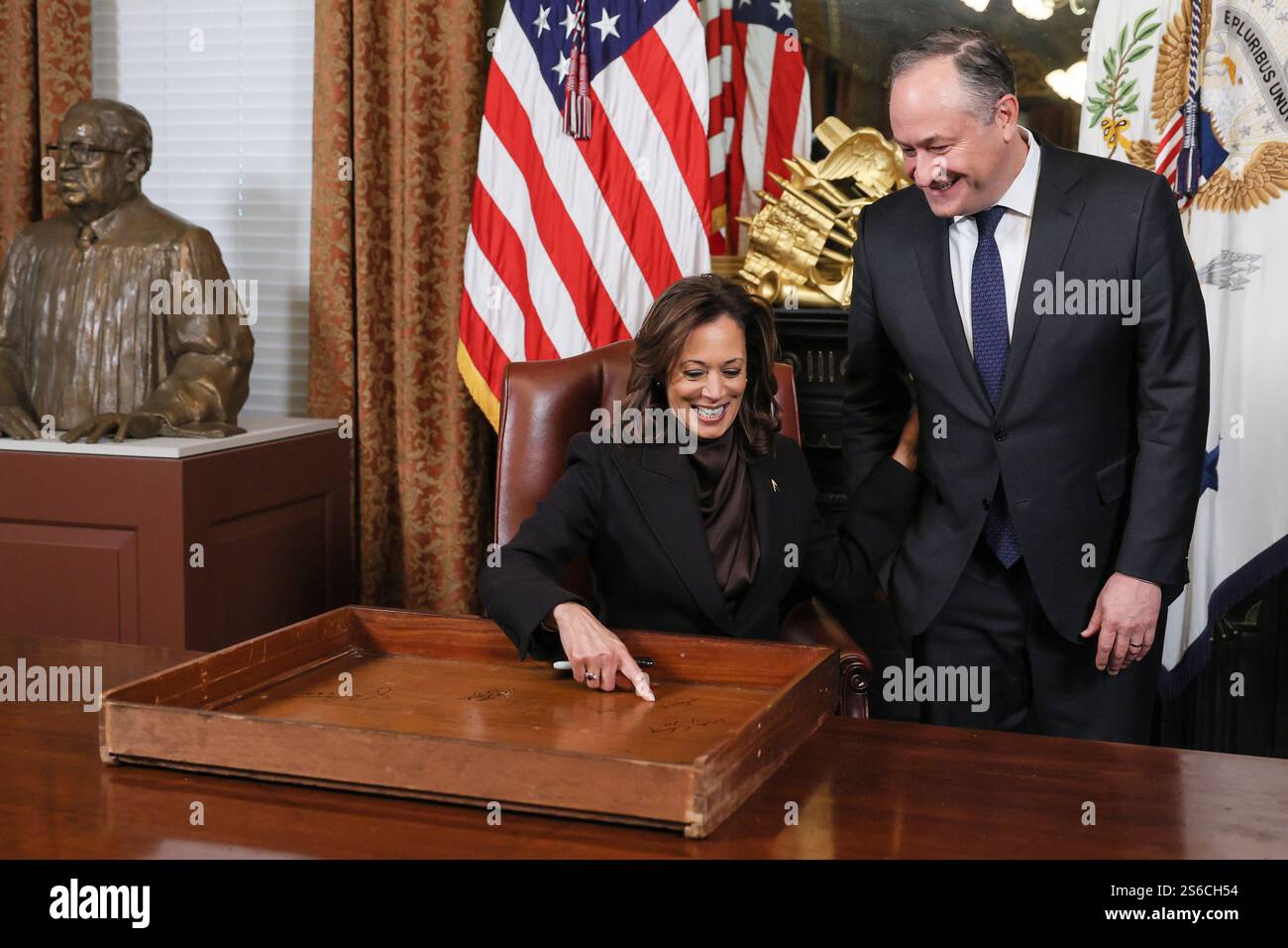 Vice President Kamala Harris points to her signature after taking part ...