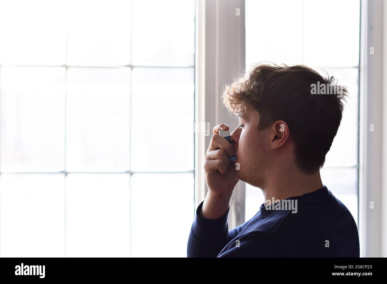 Young man using puffer inhaler to control his asthma Stock Photo - Alamy
