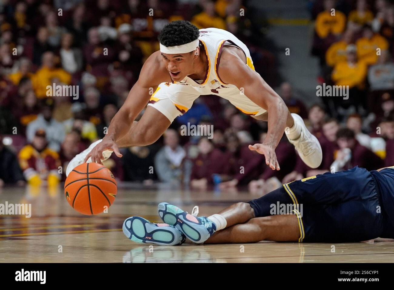 Minnesota guard Isaac Asuma (1) loses control of the ball while falling ...