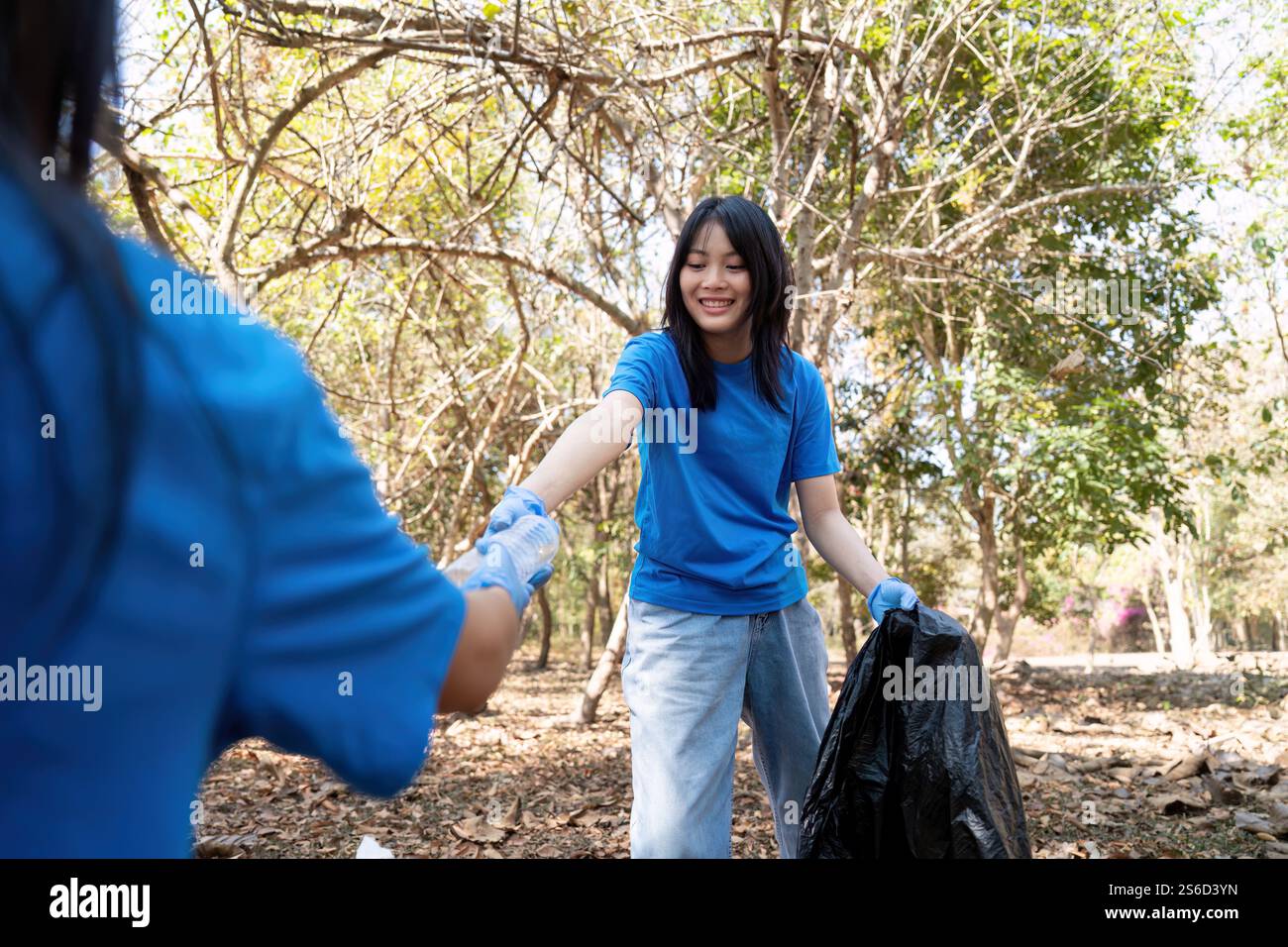 Dedicated volunteer handing over a trash bag during a community cleanup ...
