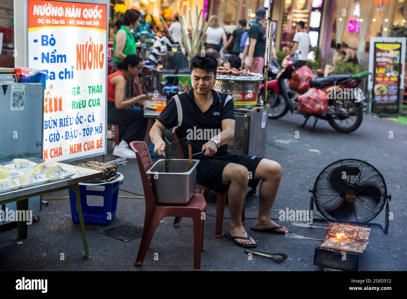 Market trader cooking meat in the street in Hanoi, Vietnam, Friday ...