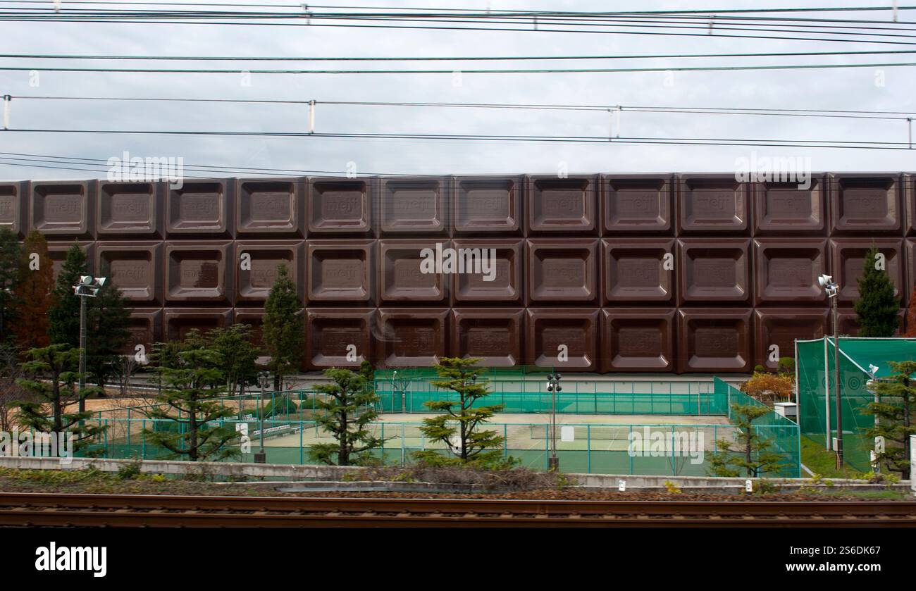 Giant chocolate bar seen from JR train line in Takatsuki near Osaka: the facade of Meiji ...
