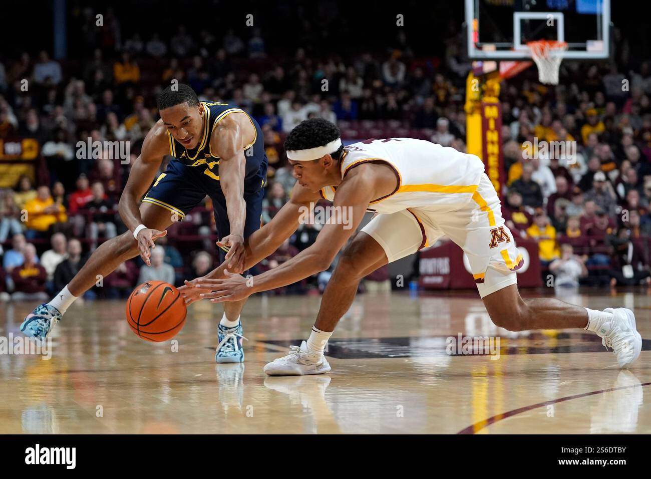 Michigan guard Nimari Burnett, left, and Minnesota guard Isaac Asuma ...