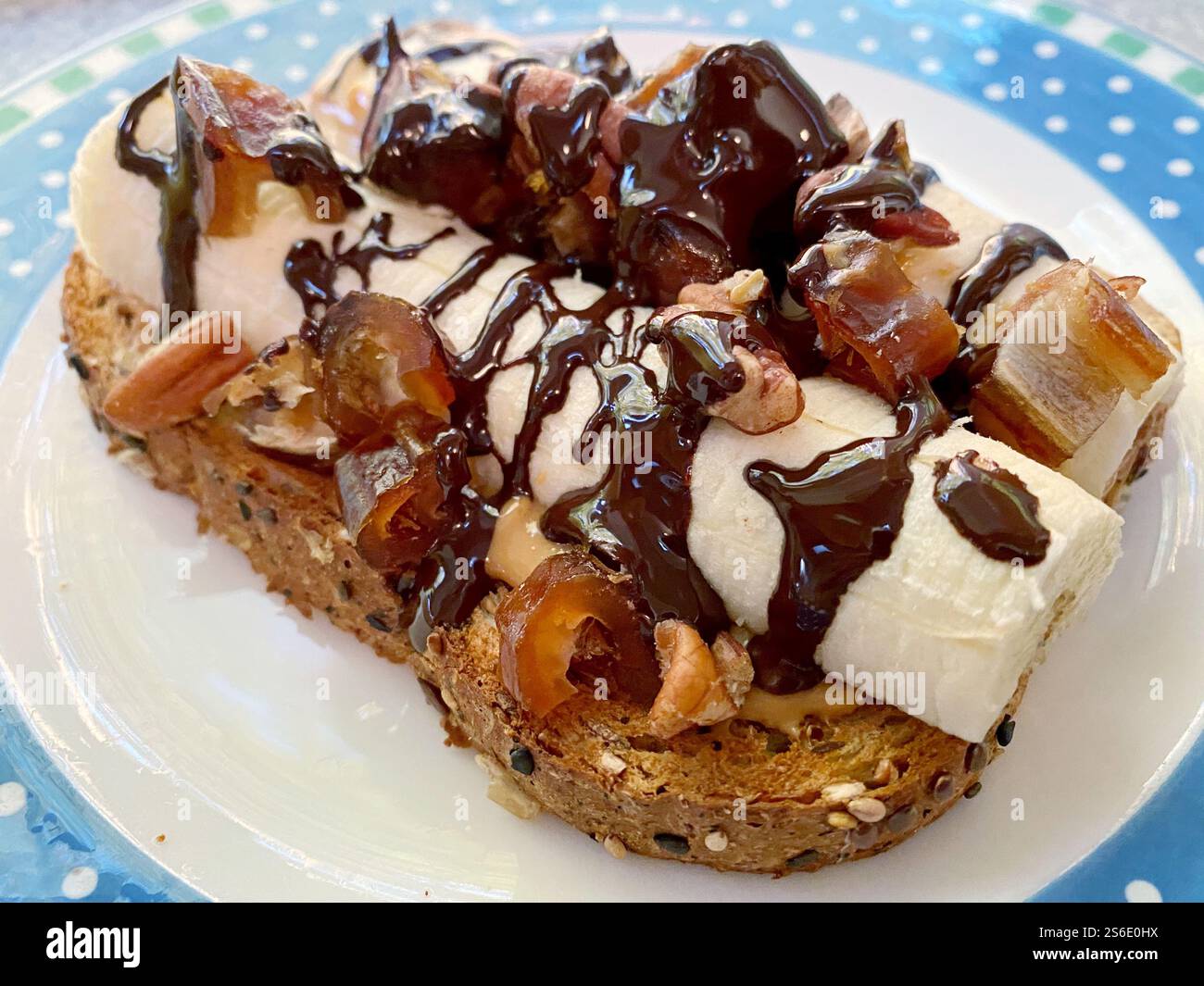 Toast with peanut butter, banana, chopped dates and drizzled chocolate ...