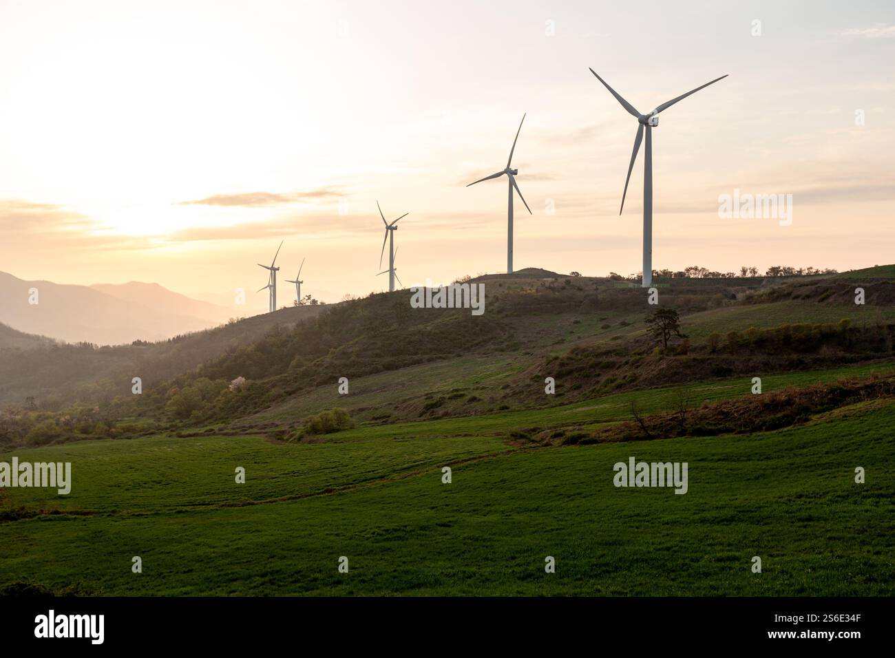 A beautiful farm with wind turbines, mountain and field sunrise Stock ...