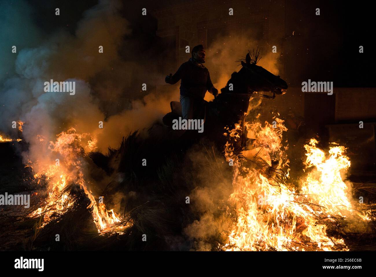 A rider on his horse crosses a bonfire during the celebration of the ...
