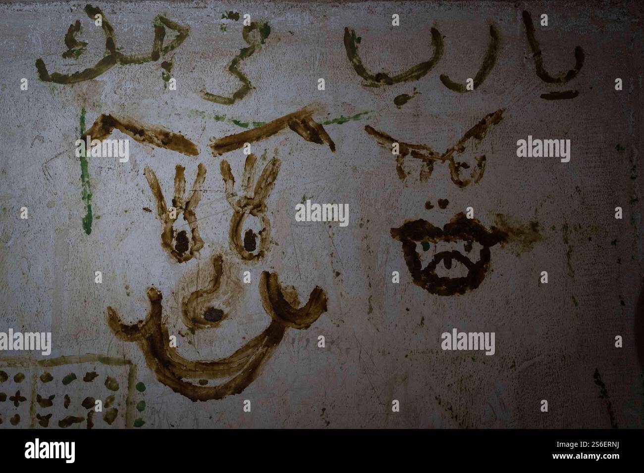 A graffiti in Arabic on the wall of a prison cell reads "Oh Lord, bring ...