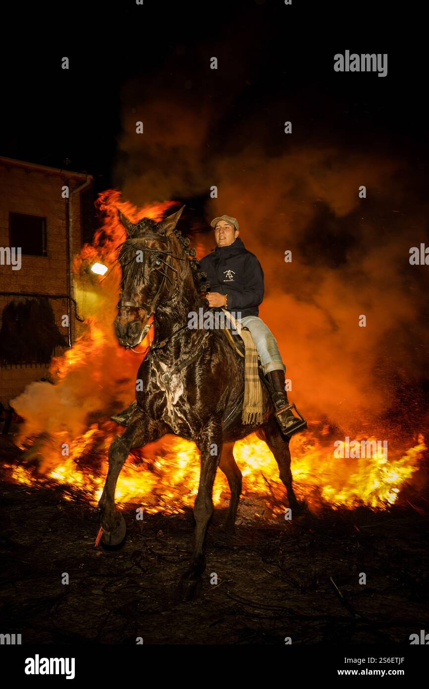 A horseman jumps over a bonfire in the village of San Bartolome de ...
