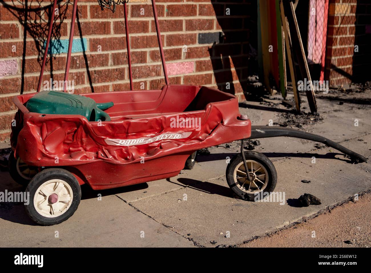 A melted Radio Flyer wagon sits outside the burned down Marquez School ...