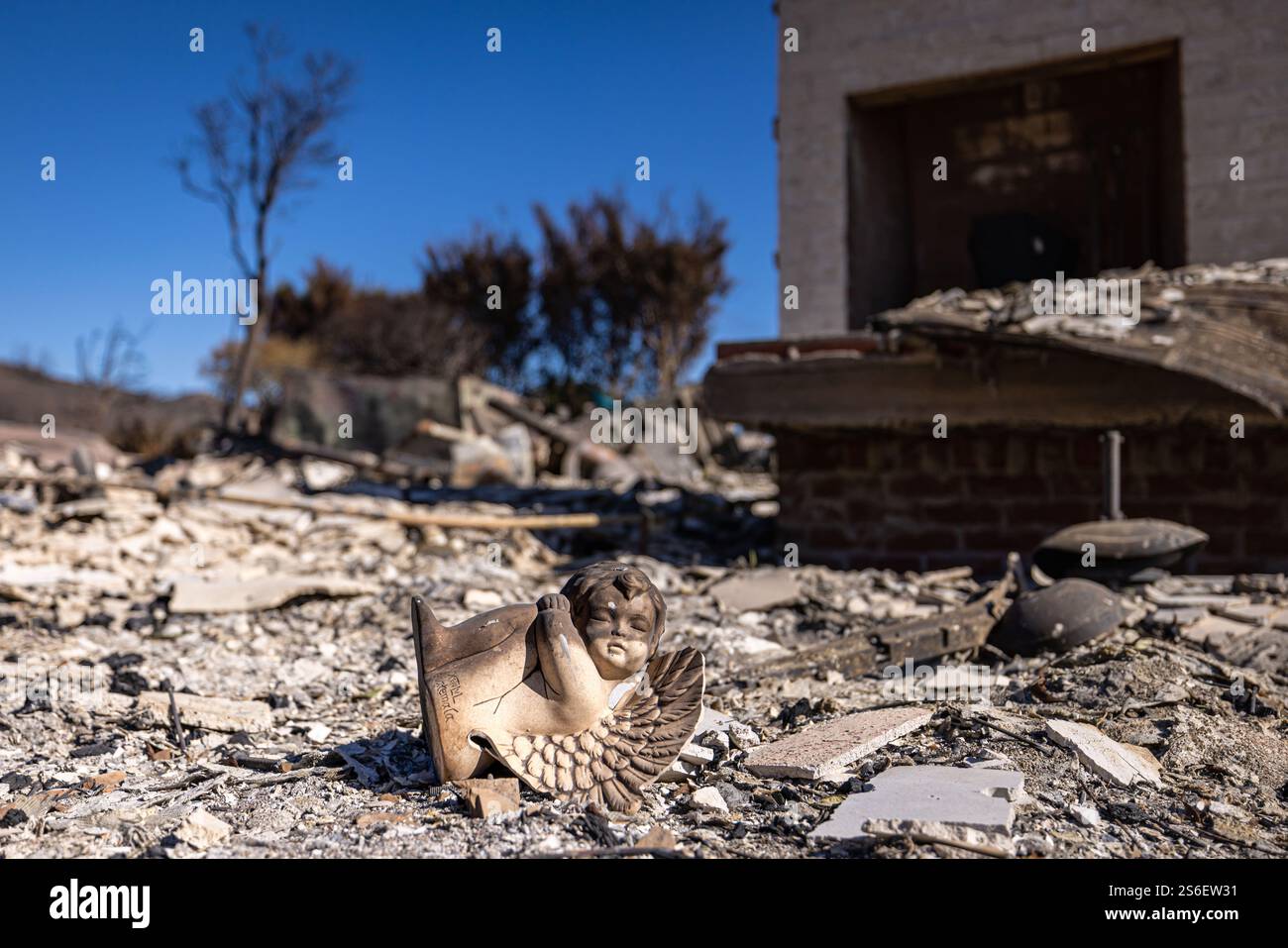 A singed sculpture of an angel lays in the ash-heap remains of a home ...