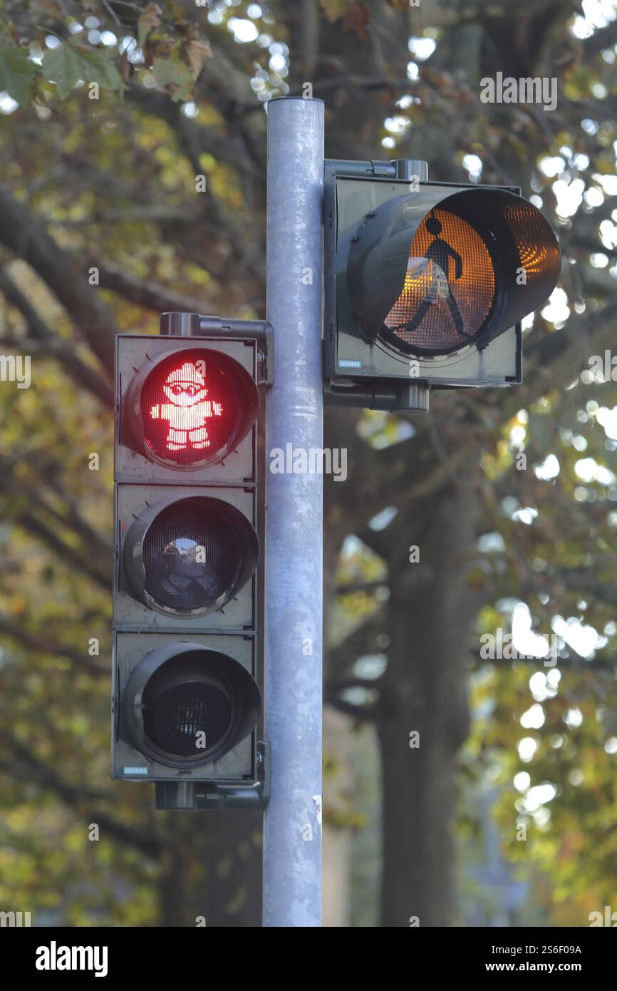Red pedestrian traffic light with orange flashing light and ...