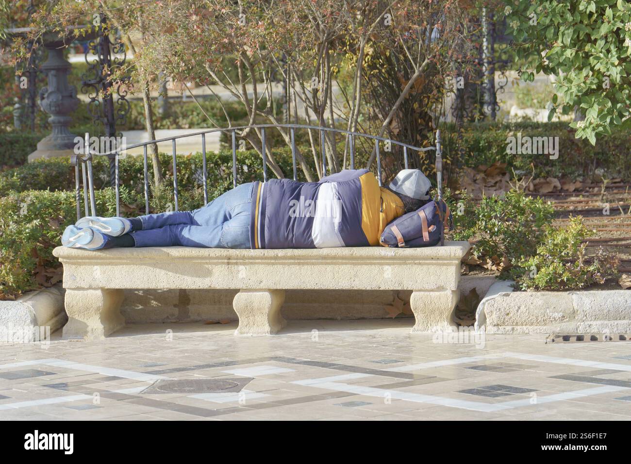 Homeless man sleeping on a park bench Stock Photo - Alamy