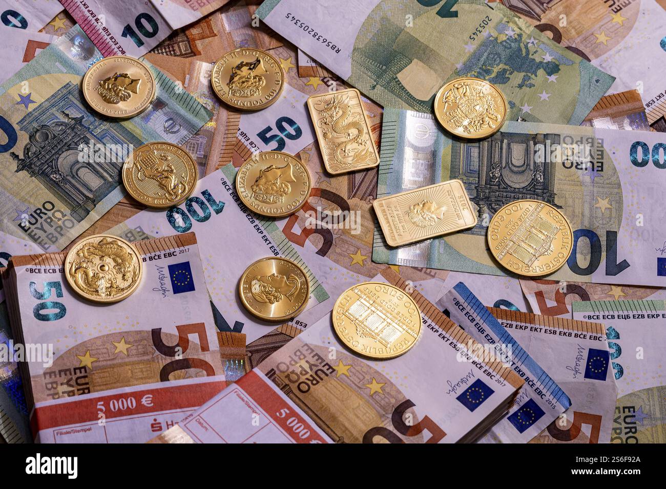 Gold and banknotes, ounce bars and coins, various euro notes in piles ...