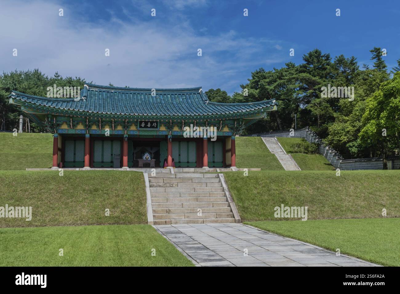 Traditional building with a blue roof and stairs, surrounded by grass ...