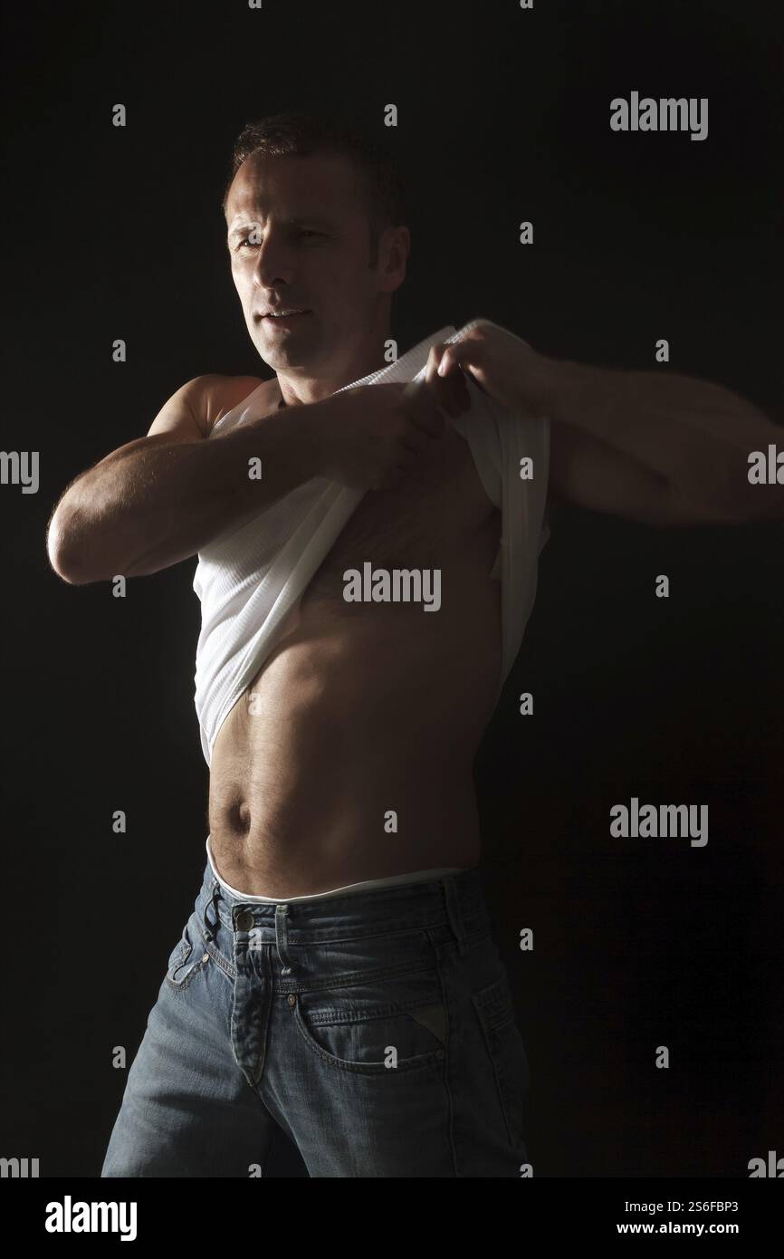 An image of a handsome muscle man lifting his shirt Stock Photo - Alamy