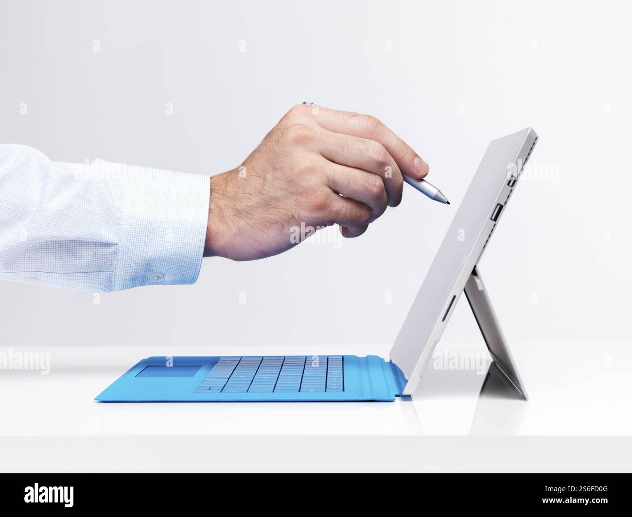 Closeup of a man's hand with a pen touching display of Microsoft ...