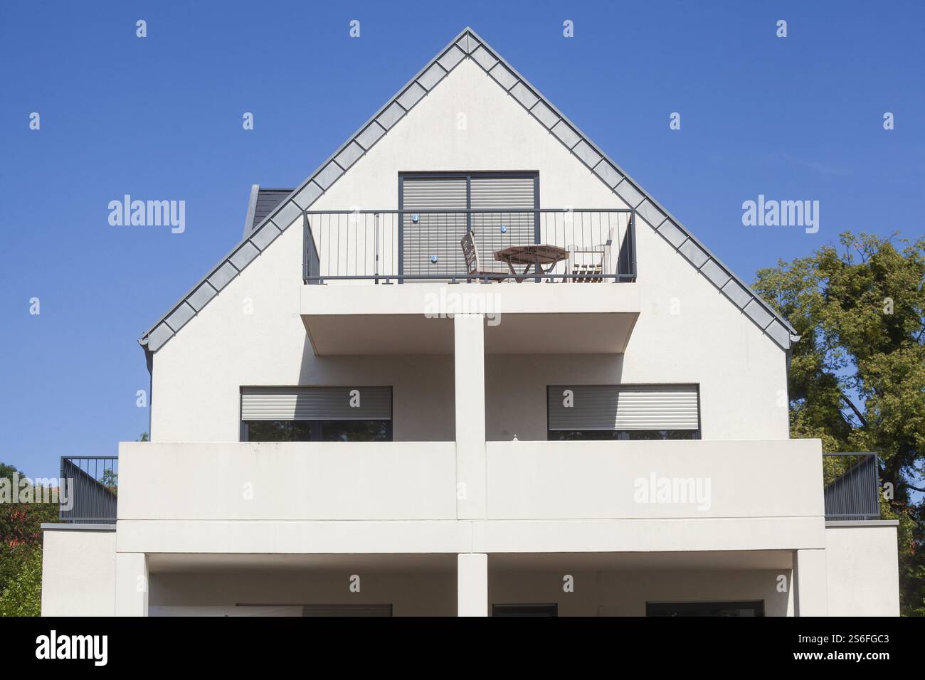Modern white residential building with balcony and roof gable ...