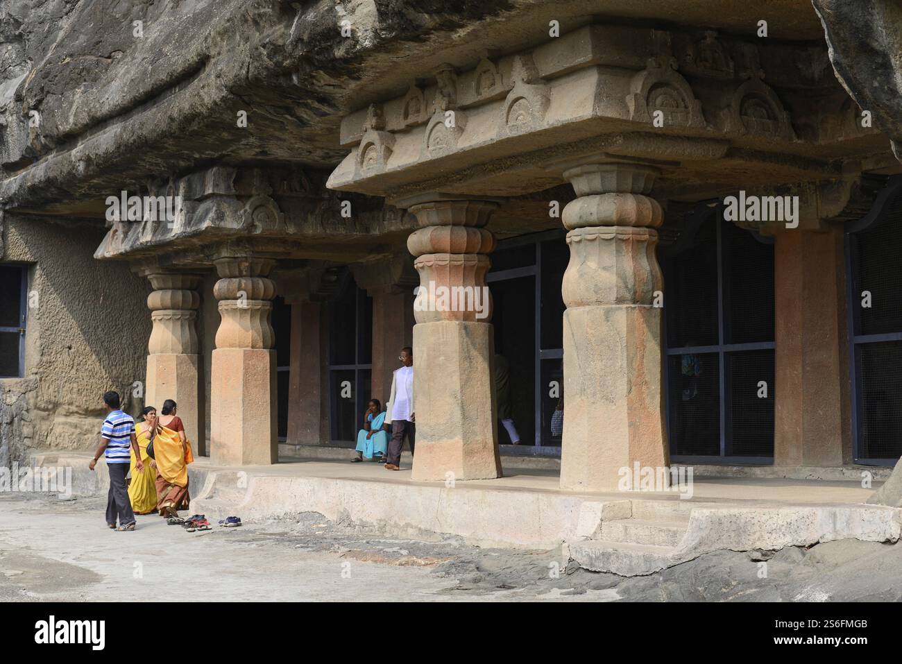 Caves of Ajanta and Ellora, people in front of large temple pillars and ...