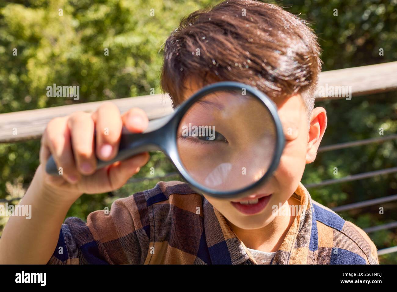 Happy boy using magnifying glass Stock Photo - Alamy