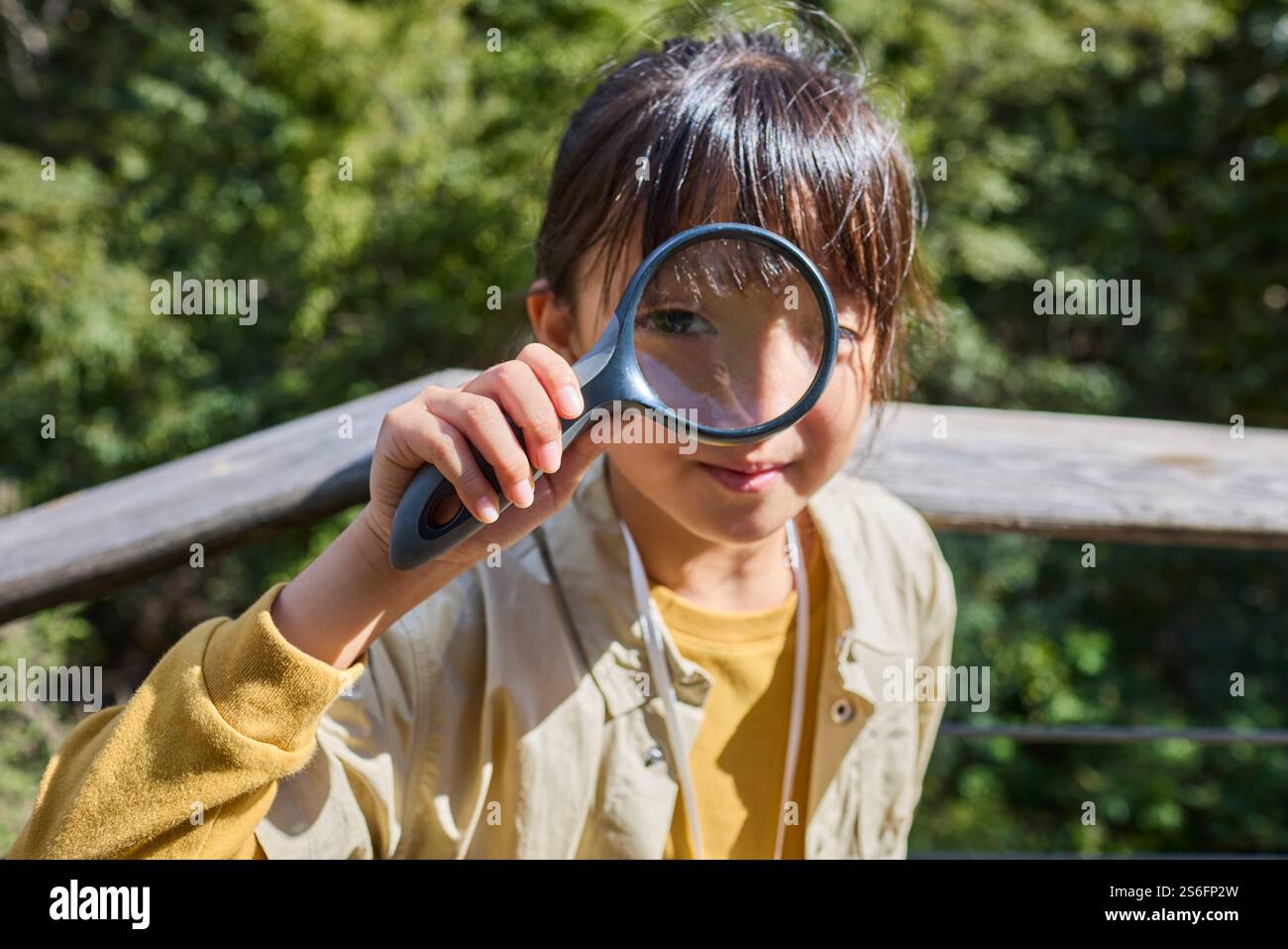 Happy girl using magnifying glass Stock Photo - Alamy