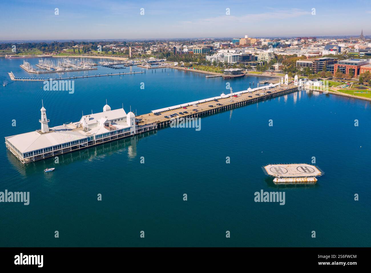 Aerial view of a city waterfront with a long narrow pier with buildings ...