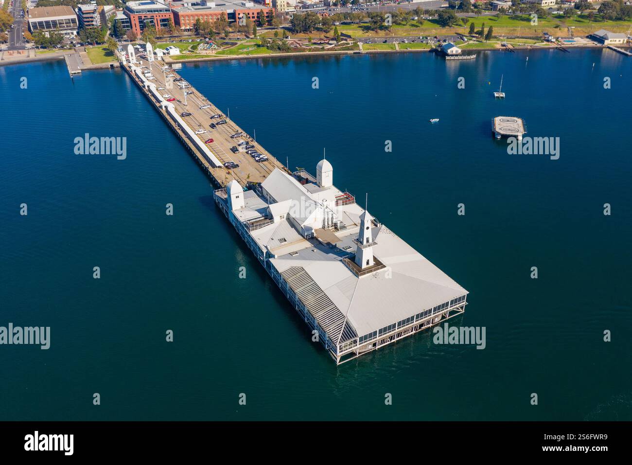 Aerial view of a city waterfront with a long narrow pier with buildings ...