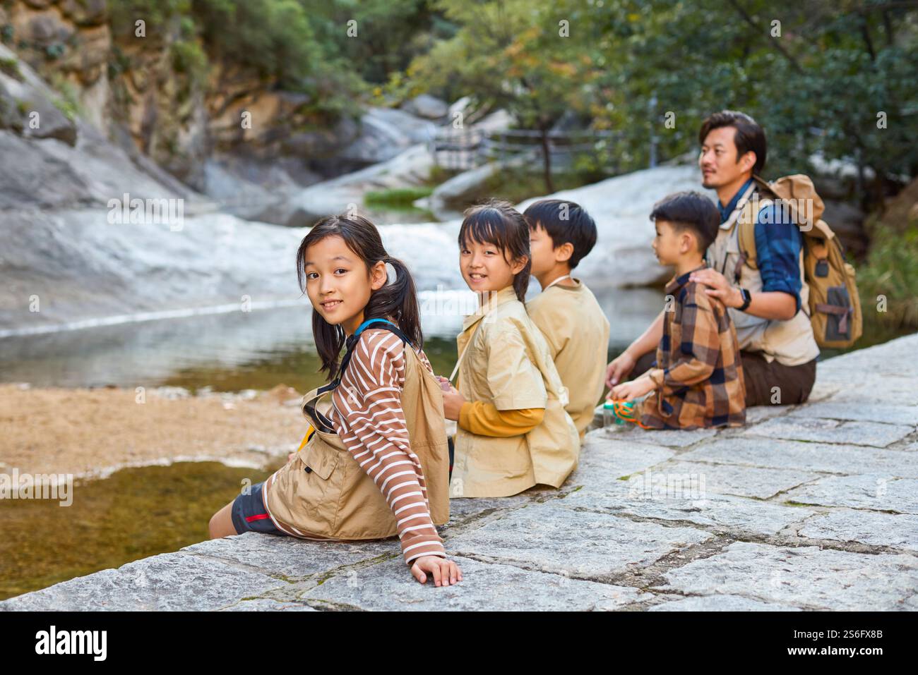 Happy teacher and kids playing by the stream Stock Photo - Alamy