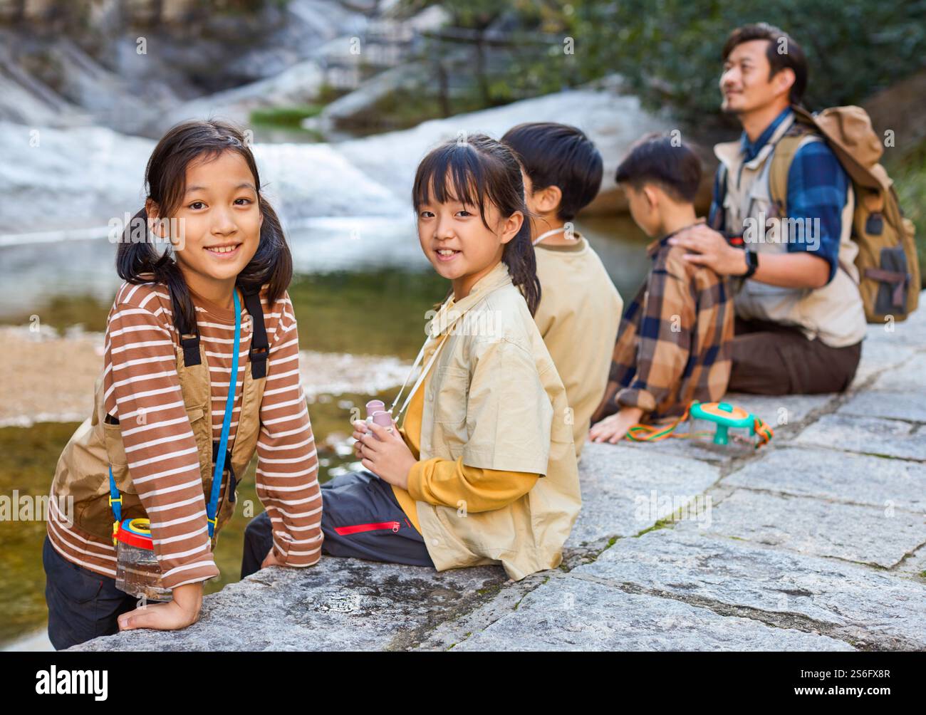 Happy teacher and kids playing by the stream Stock Photo - Alamy