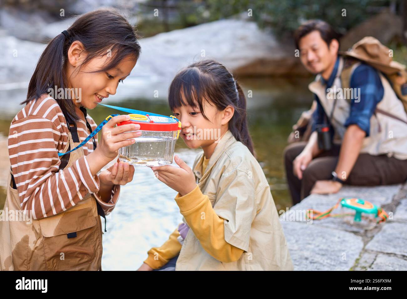 Happy teacher and kids playing by the stream Stock Photo - Alamy