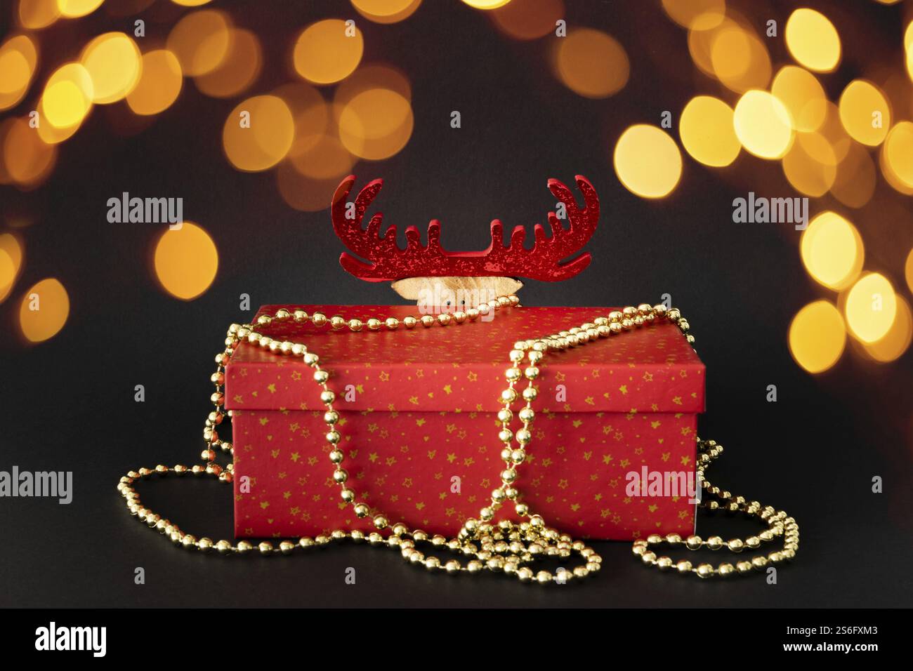 A Christmas decoration gift box with hidden reindeer figure on black ...