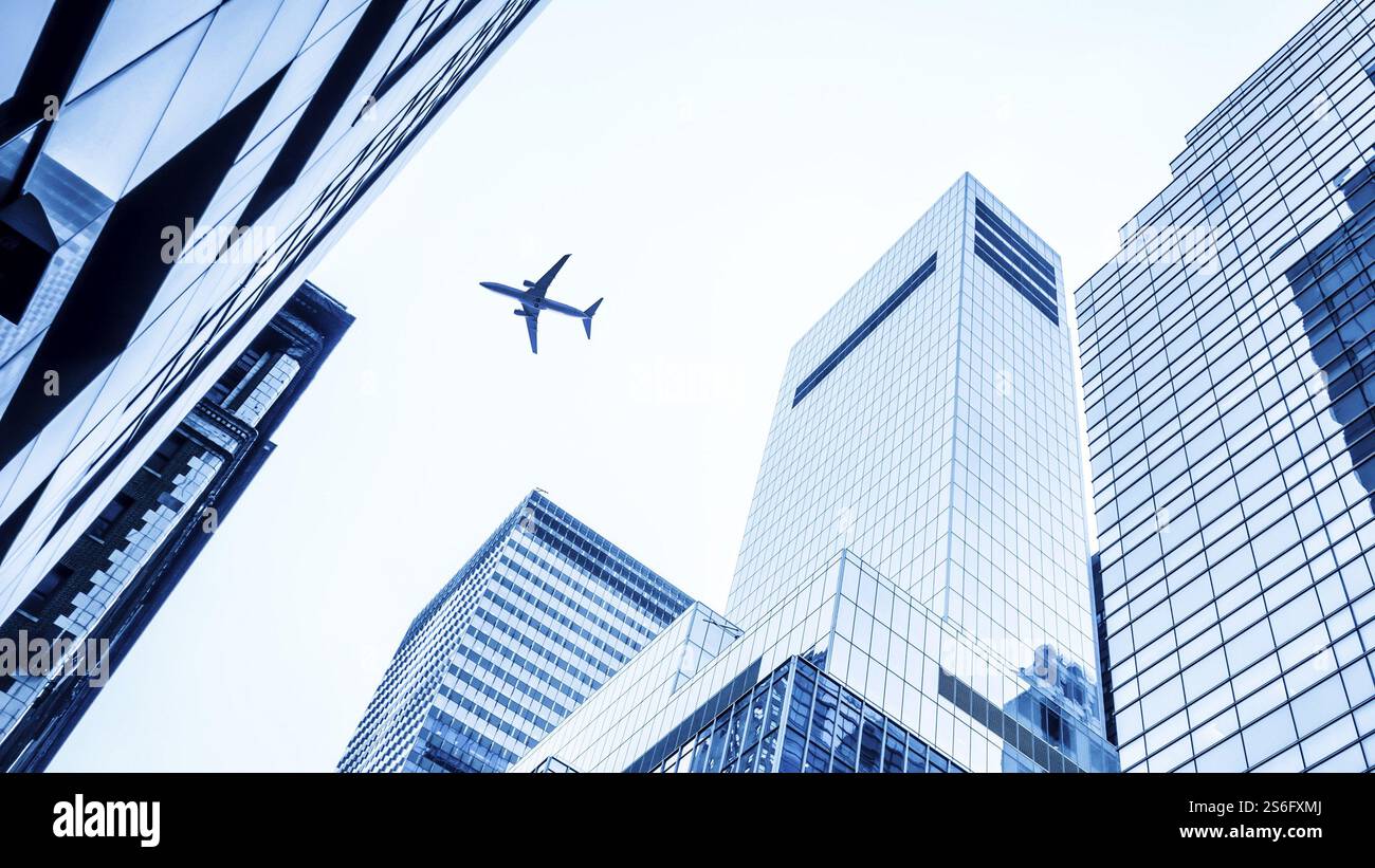 An image of a plane flying over modern buildings of New York City Stock ...
