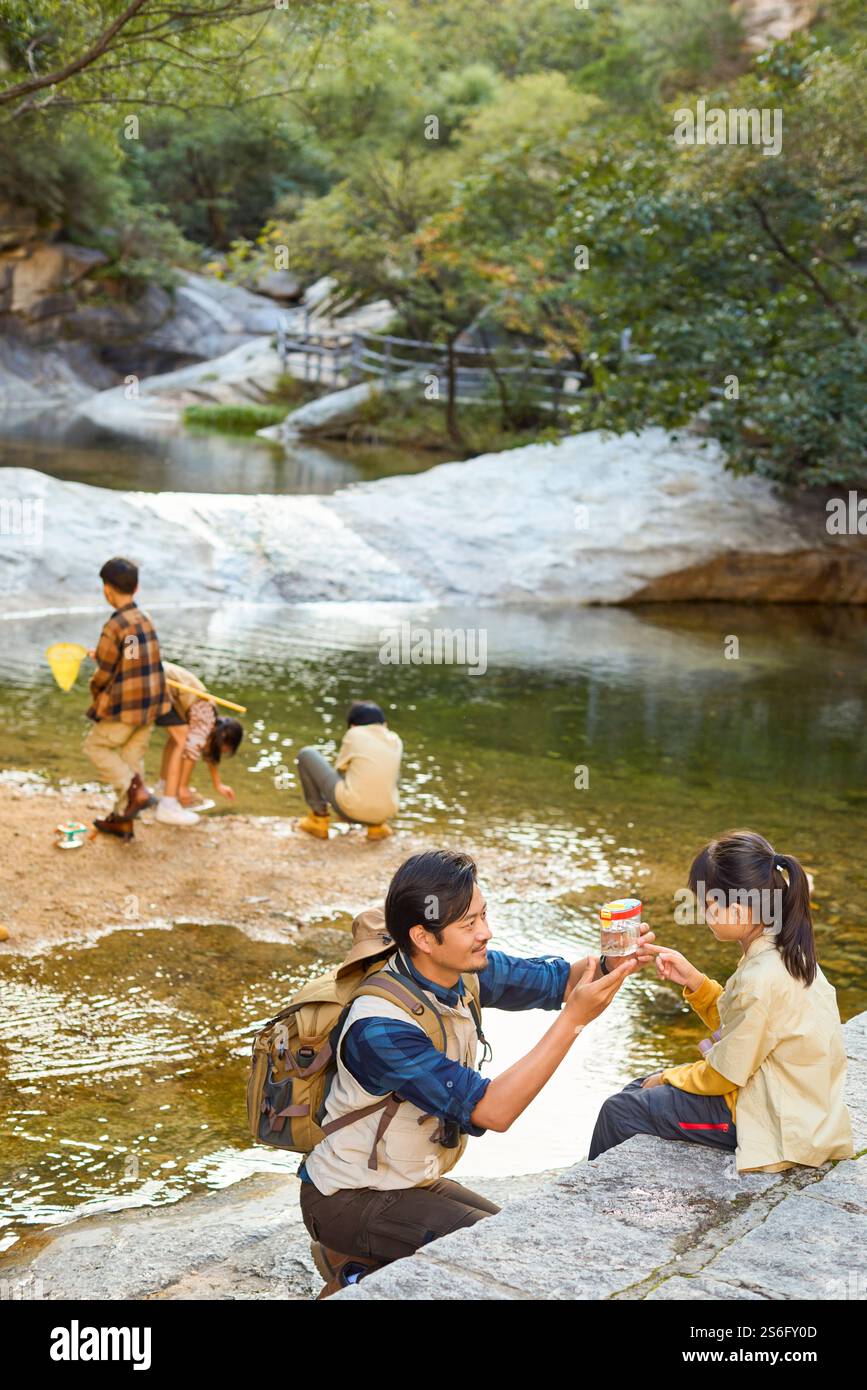 Happy teacher and kids playing by the stream Stock Photo - Alamy