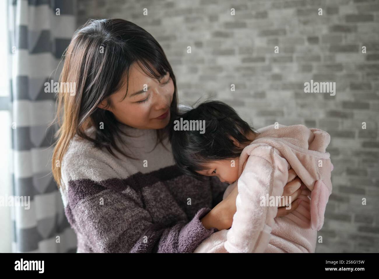 A Japanese mother in her 20s and a 6-month-old baby girl are in the room. I'm holding you Stock ...