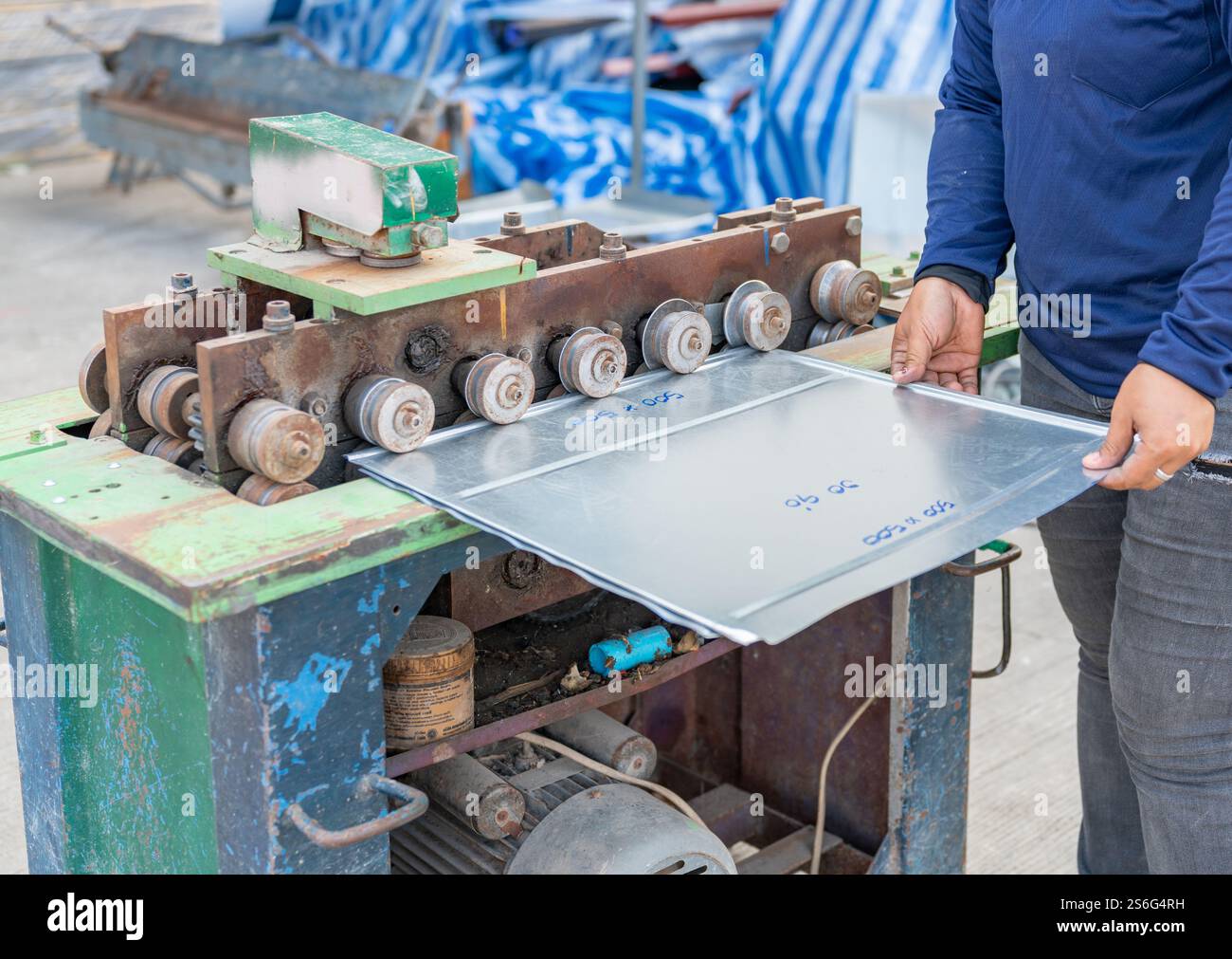 Manual worker loading metal sheet in folding machine for fold metal ...