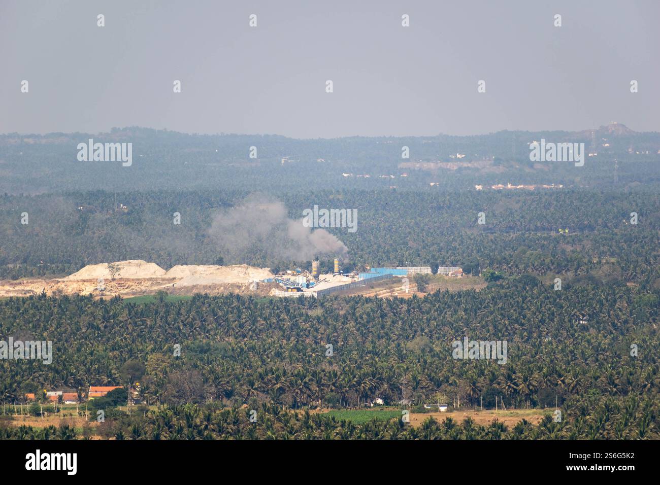 An industrial factory spewing smoke from chimneys in the middle of a ...