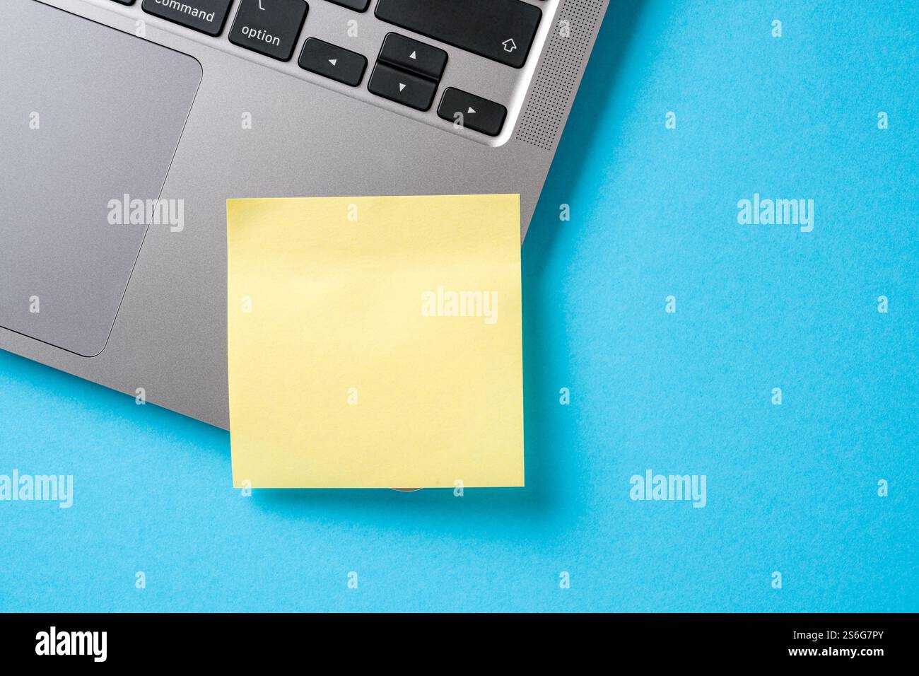 Note paper stuck to the corner of the laptop on the blue desk Stock ...