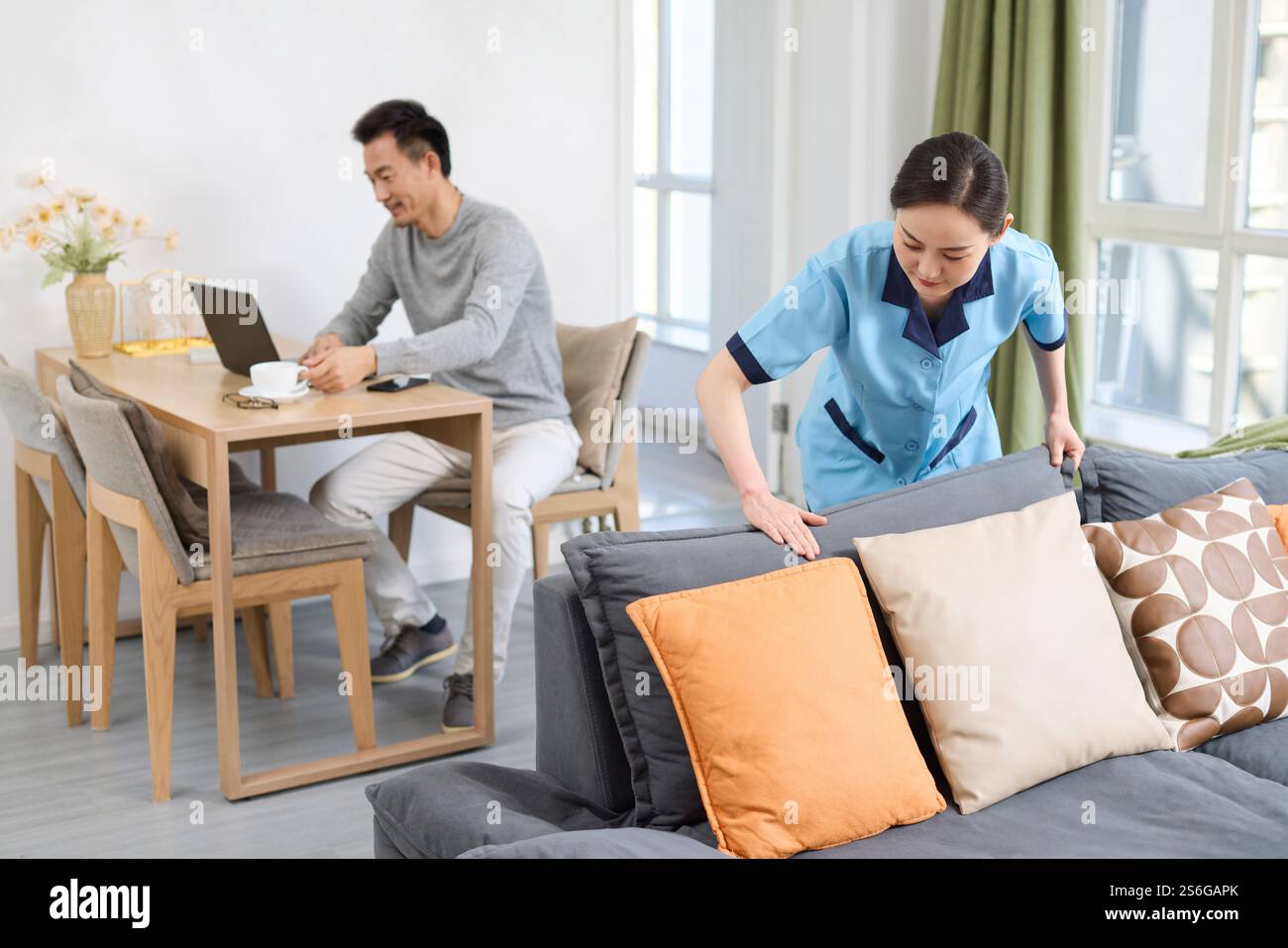 Female cleaner tidying up the apartment Stock Photo - Alamy