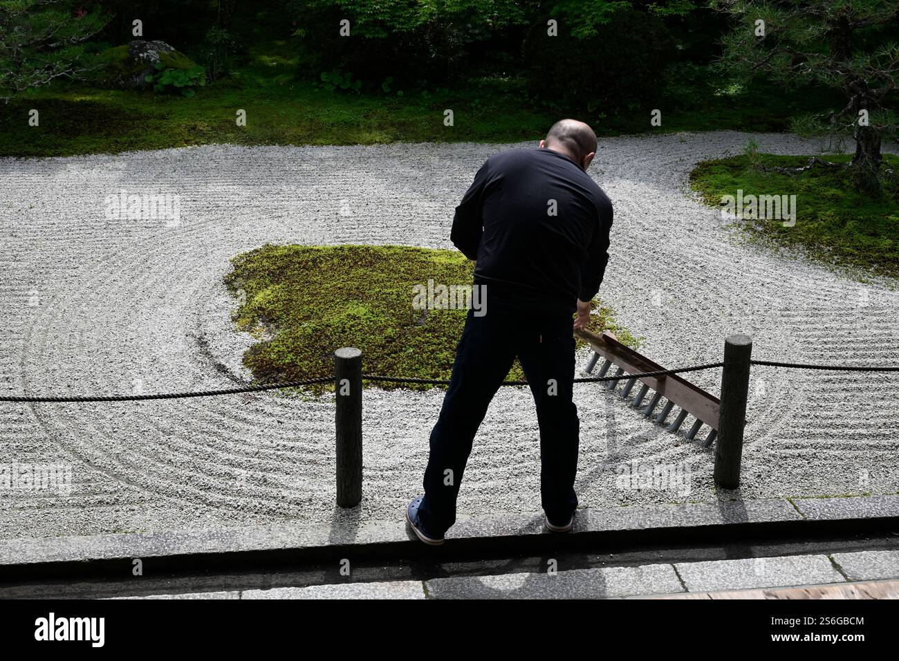 Buddhist monk raking the Zen garden of Tenjuan in the Nanzen-ji complex ...