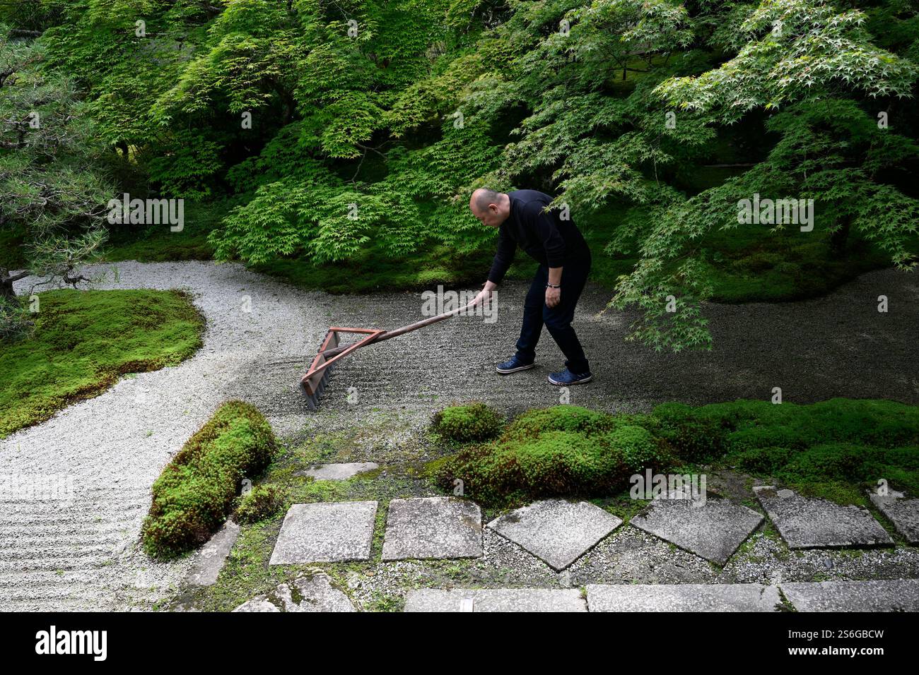 Buddhist monk raking the Zen garden of Tenjuan in the Nanzen-ji complex ...
