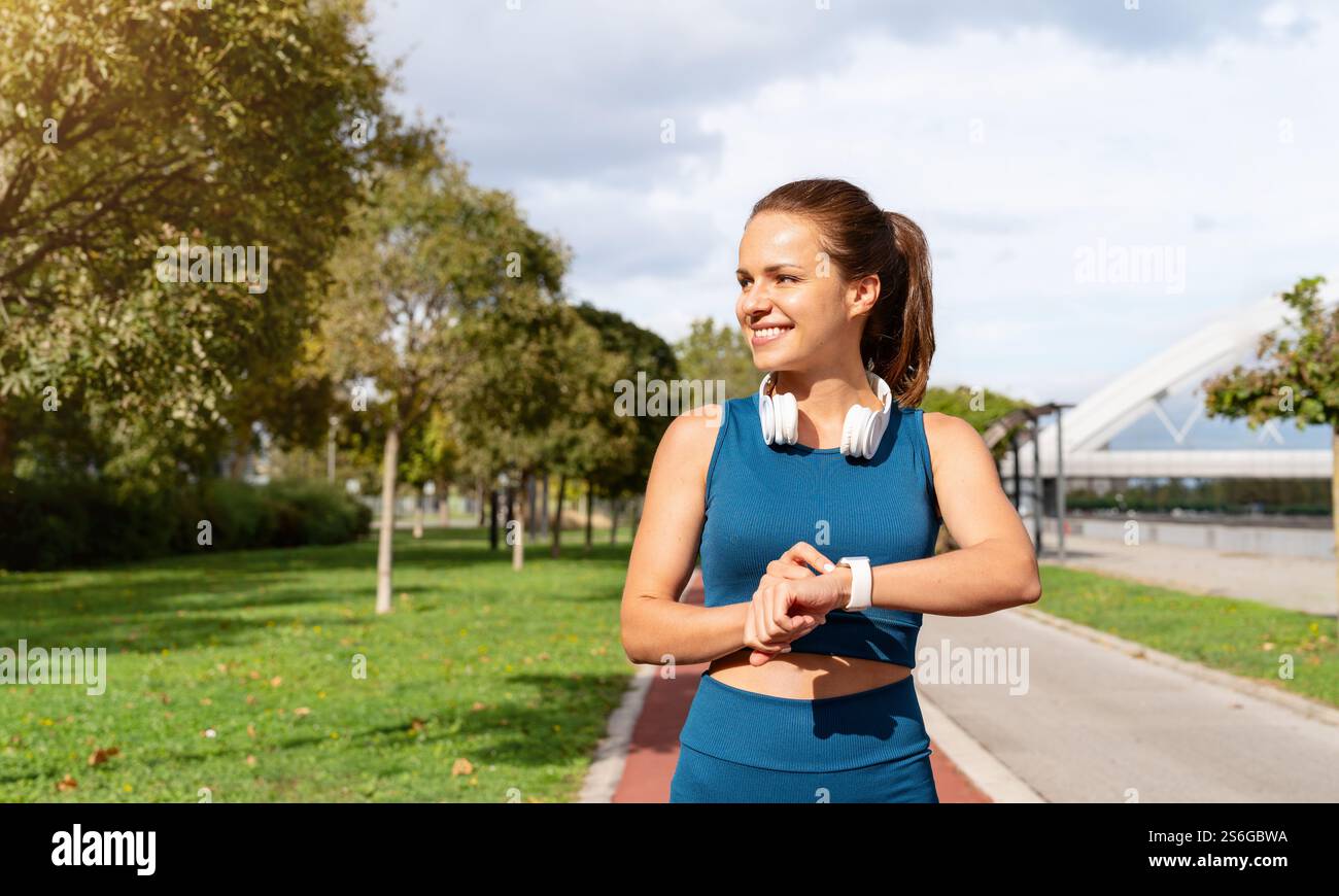 Female runner on running track using her smartwatch tracker during ...