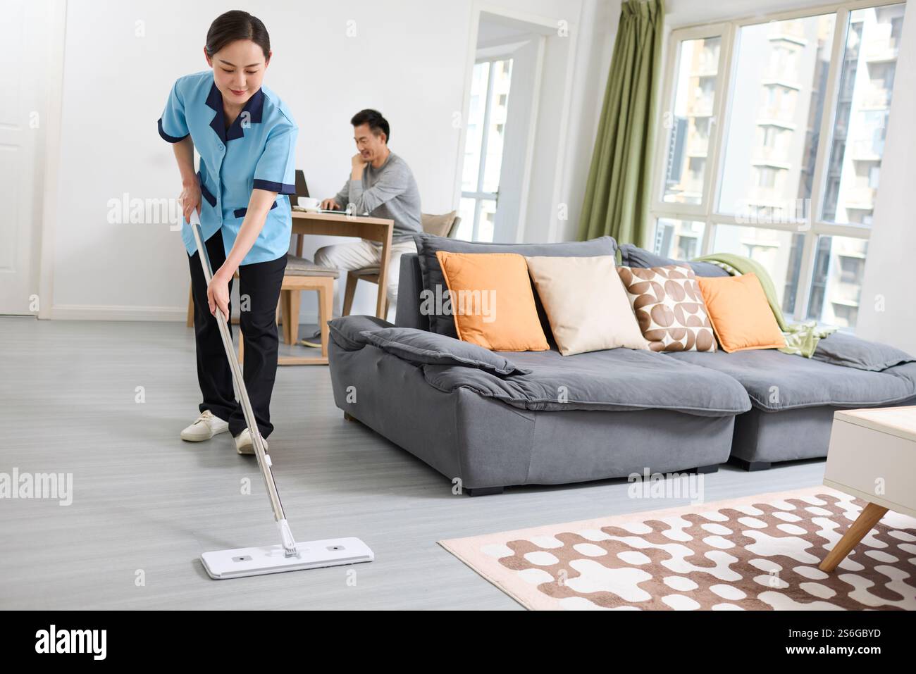 Female cleaner tidying up the apartment Stock Photo - Alamy