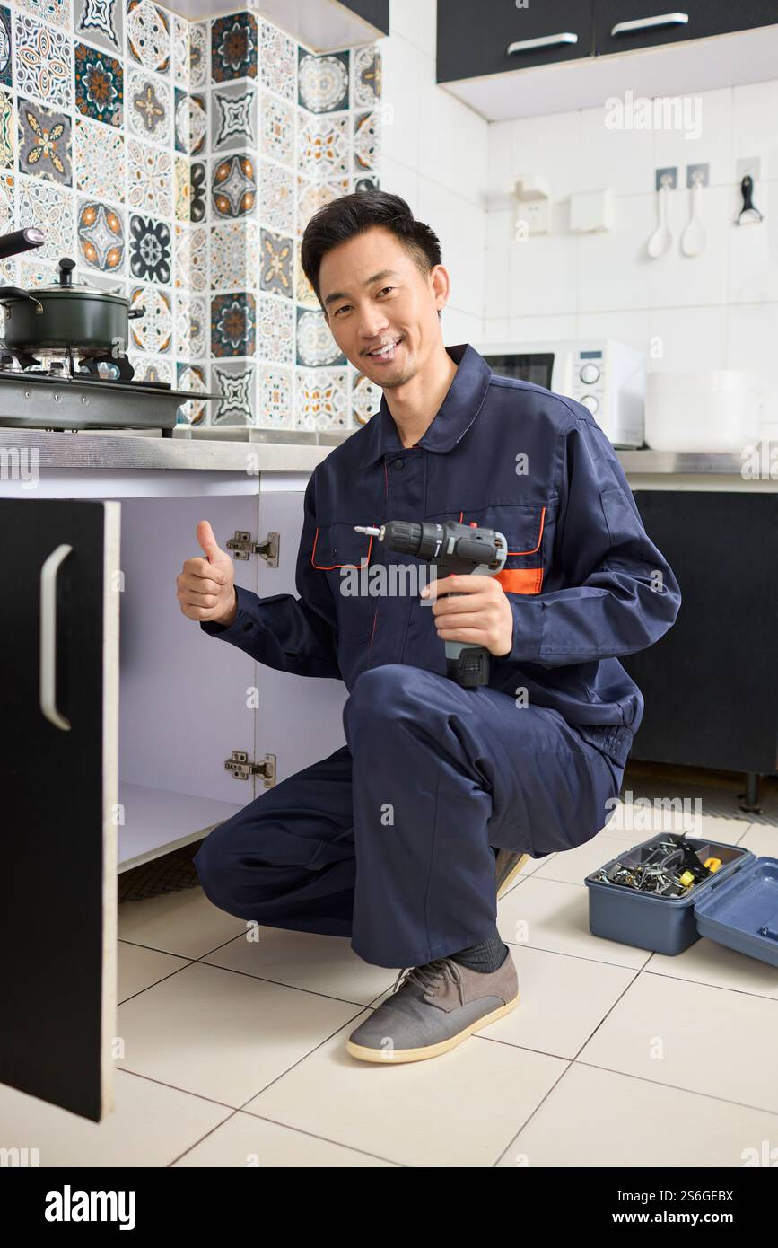 Handyman repairing the kitchen cabinet Stock Photo - Alamy