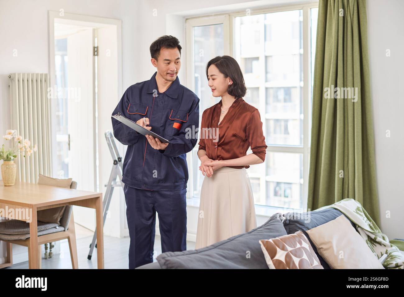 Handyman asking client to sign the work order Stock Photo - Alamy
