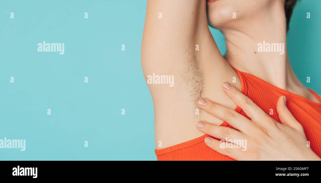 A hairy female armpit. A woman showing natural vegetation on her body. Panoramic banner. a place ...
