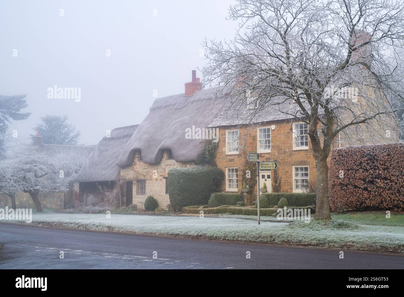 House and thatched cottage in the winter mist and frost. Honington ...